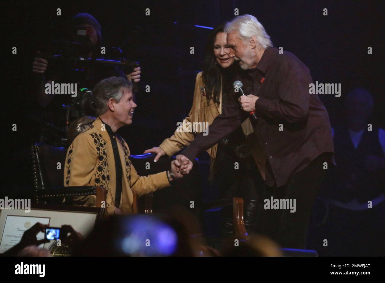 From left, artist Randy Travis and Mary Travis are greeted by artist ...