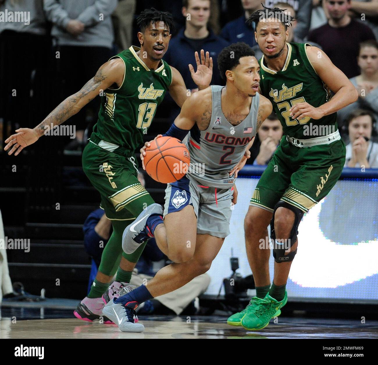 Connecticut's Jalen Adams, center, is guarded by South Florida's Geno ...