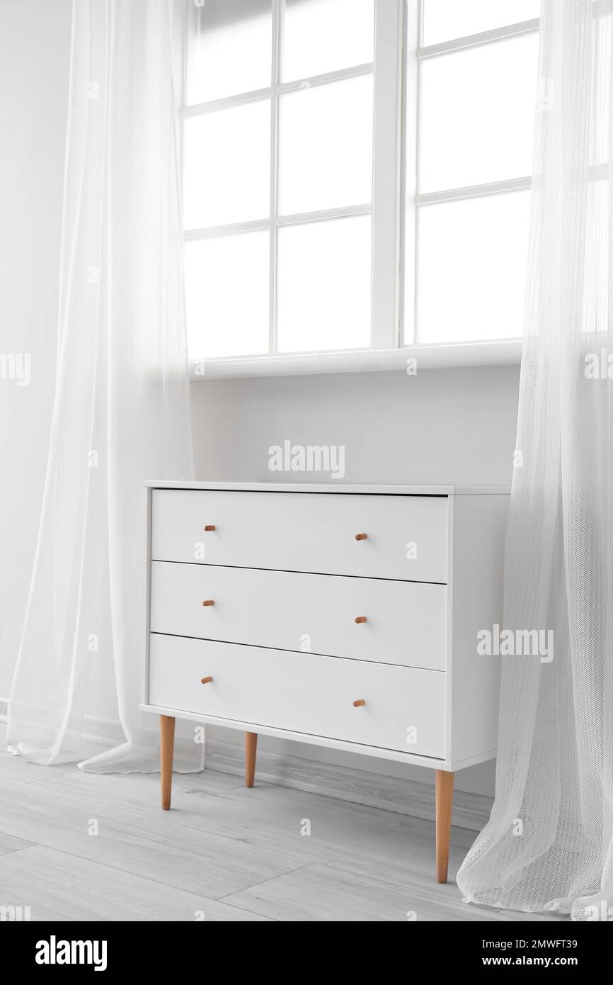 White chest of drawers near window Stock Photo - Alamy