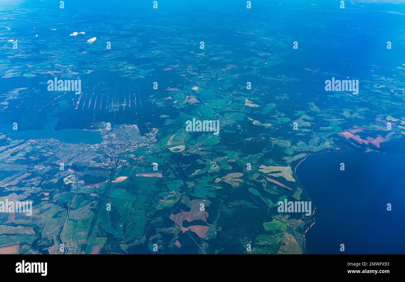 Aerial view from airplane window above green ground. View from the ...
