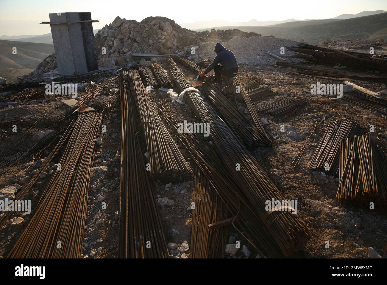 A Palestinian laborer works at a construction site in a new housing ...