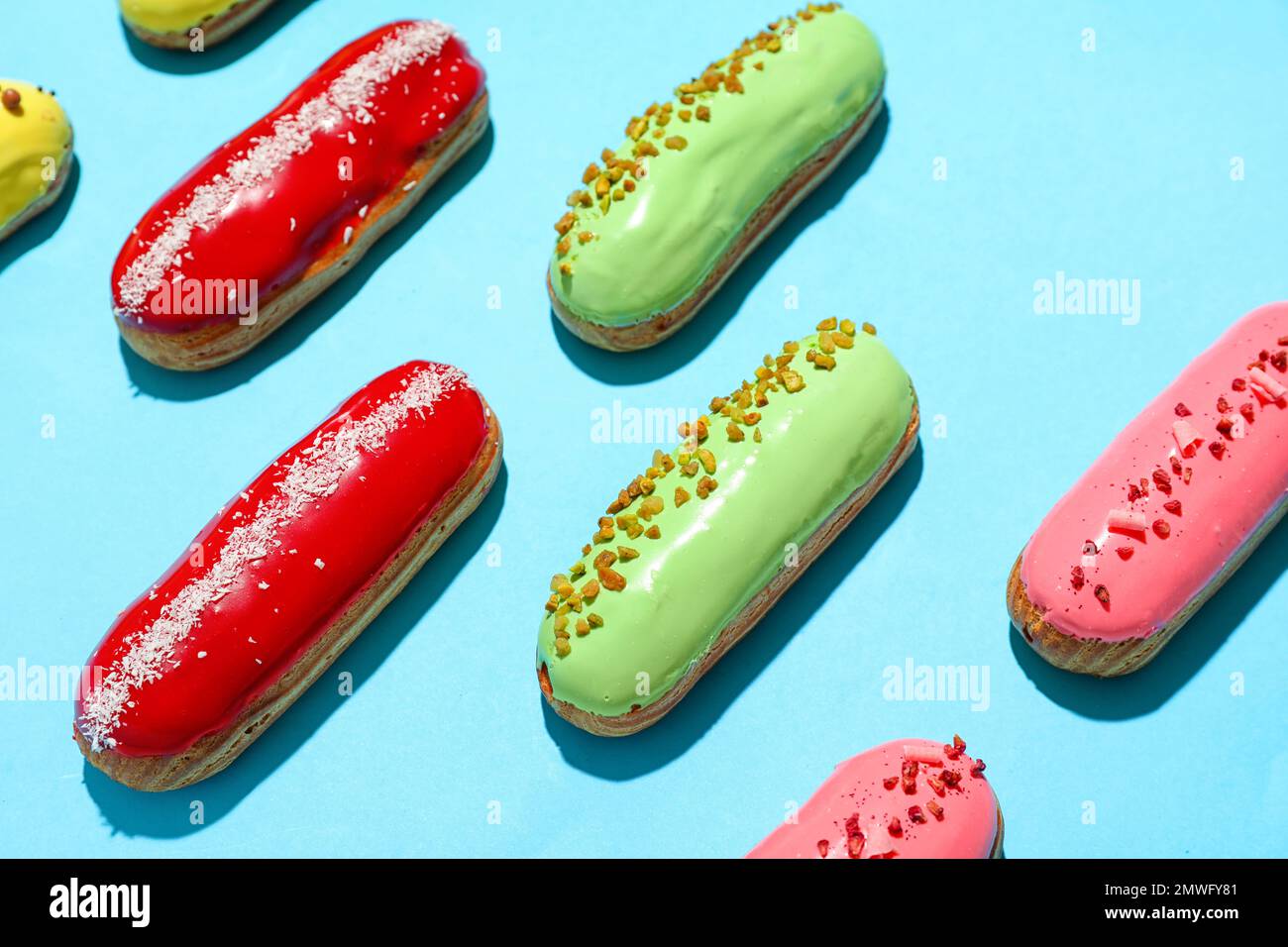 Composition with delicious eclairs on blue background Stock Photo - Alamy