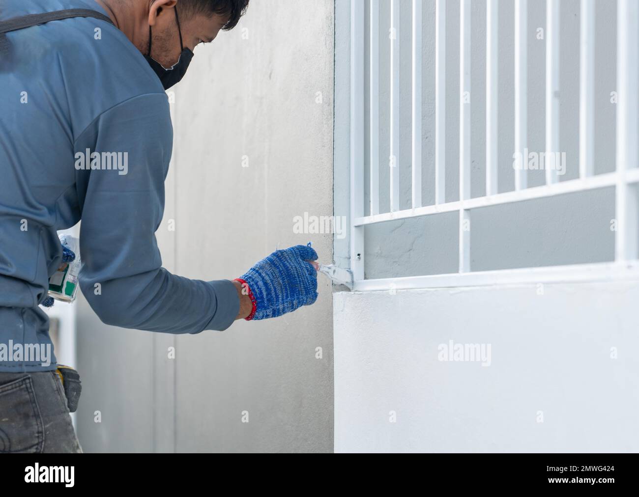 Worker paint the bars behind the room detailing after install in ...