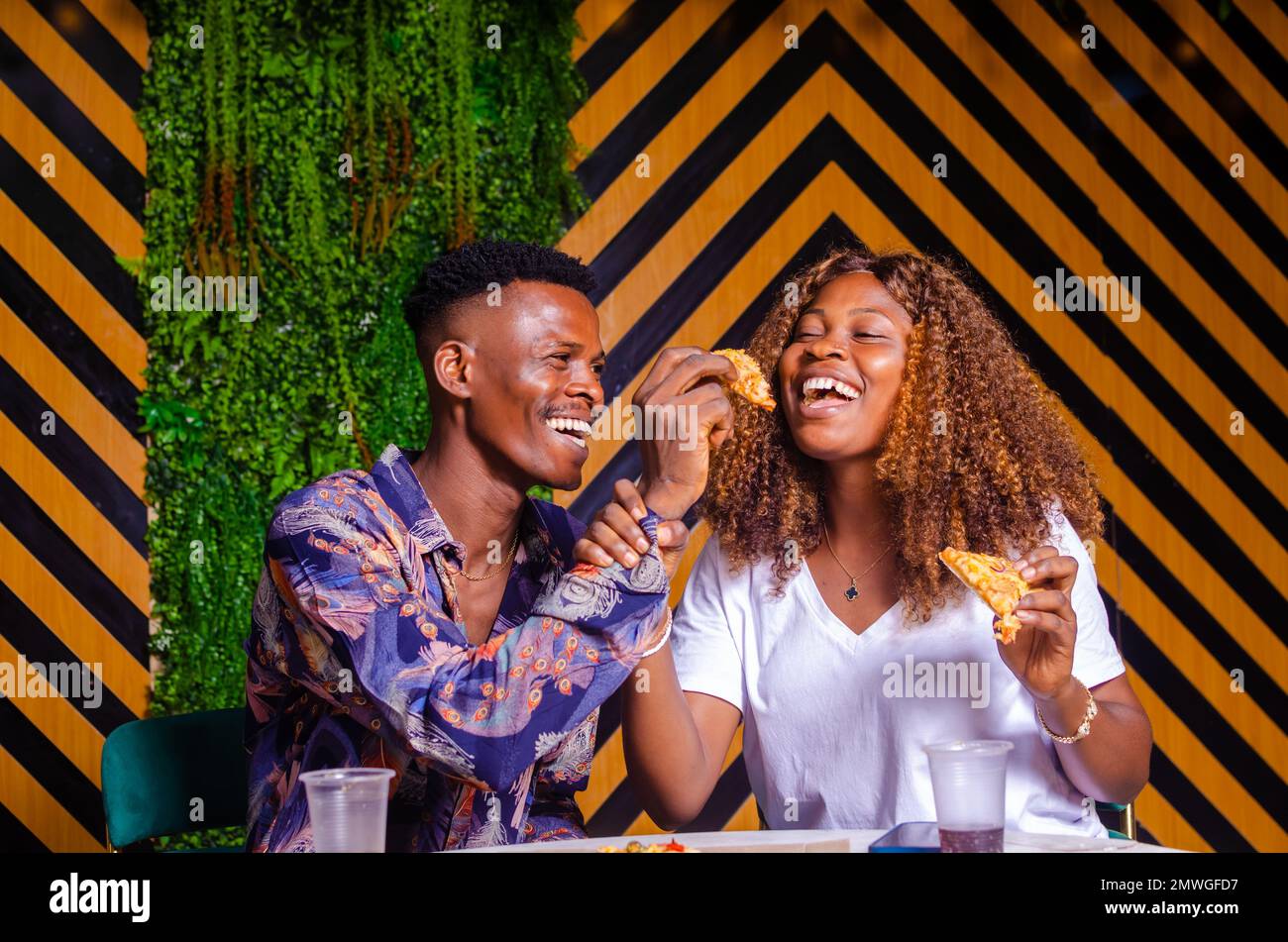 Black couple eating pizza hi-res stock photography and images - Alamy