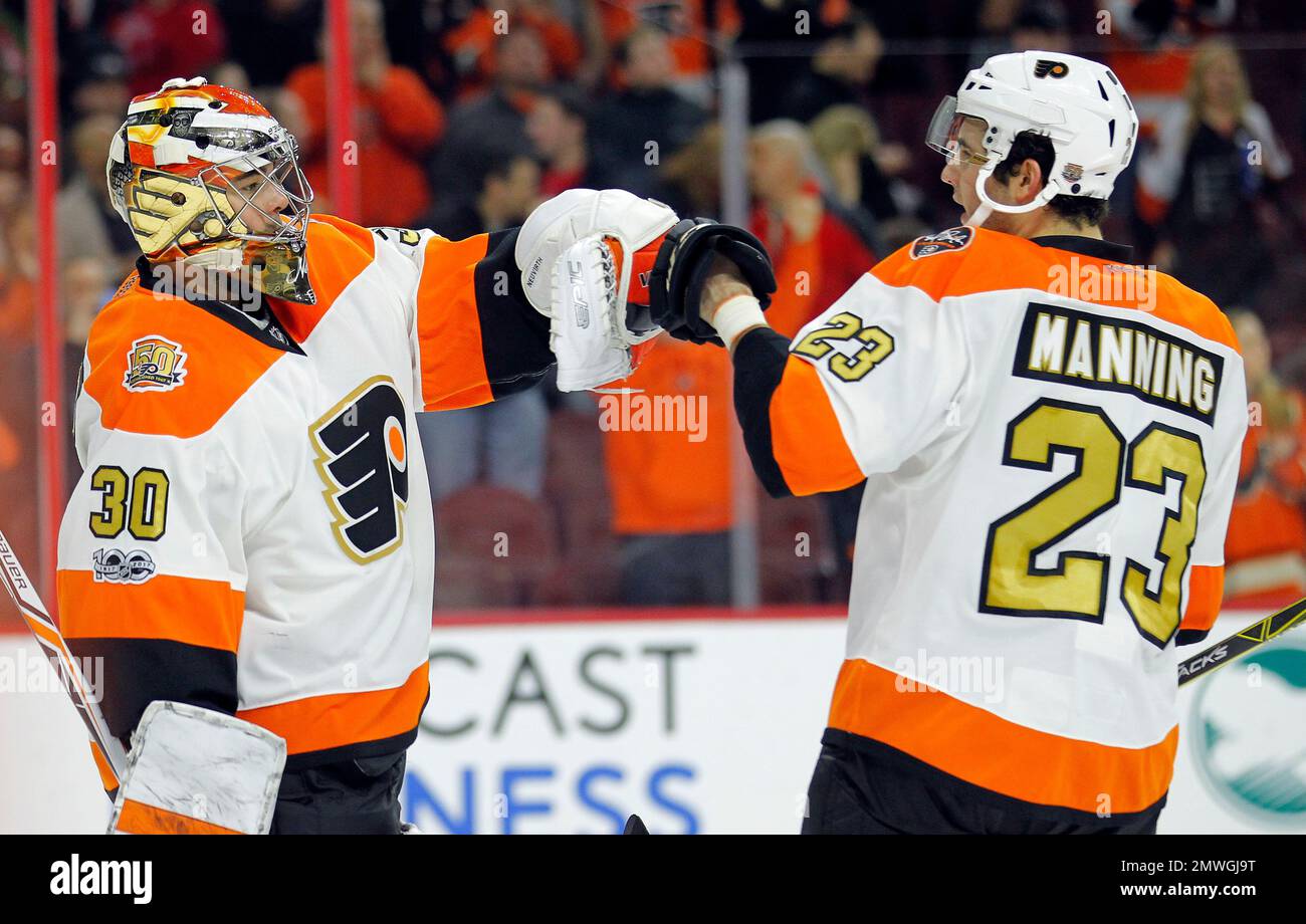 Philadelphia Flyers' Michal Neuvirth, left, and Brandon Manning tap ...