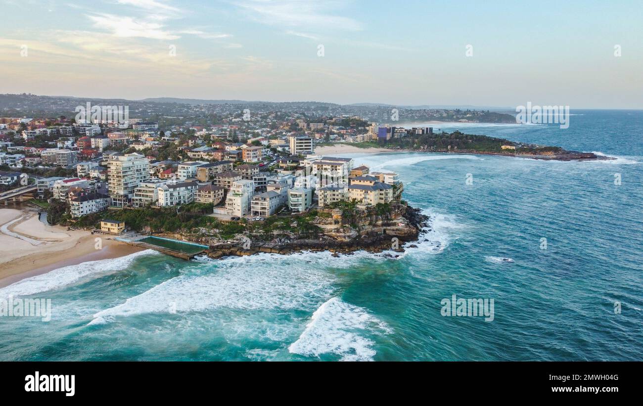 An aerial shot of modern city buildings against the wavy sea in Sydney ...