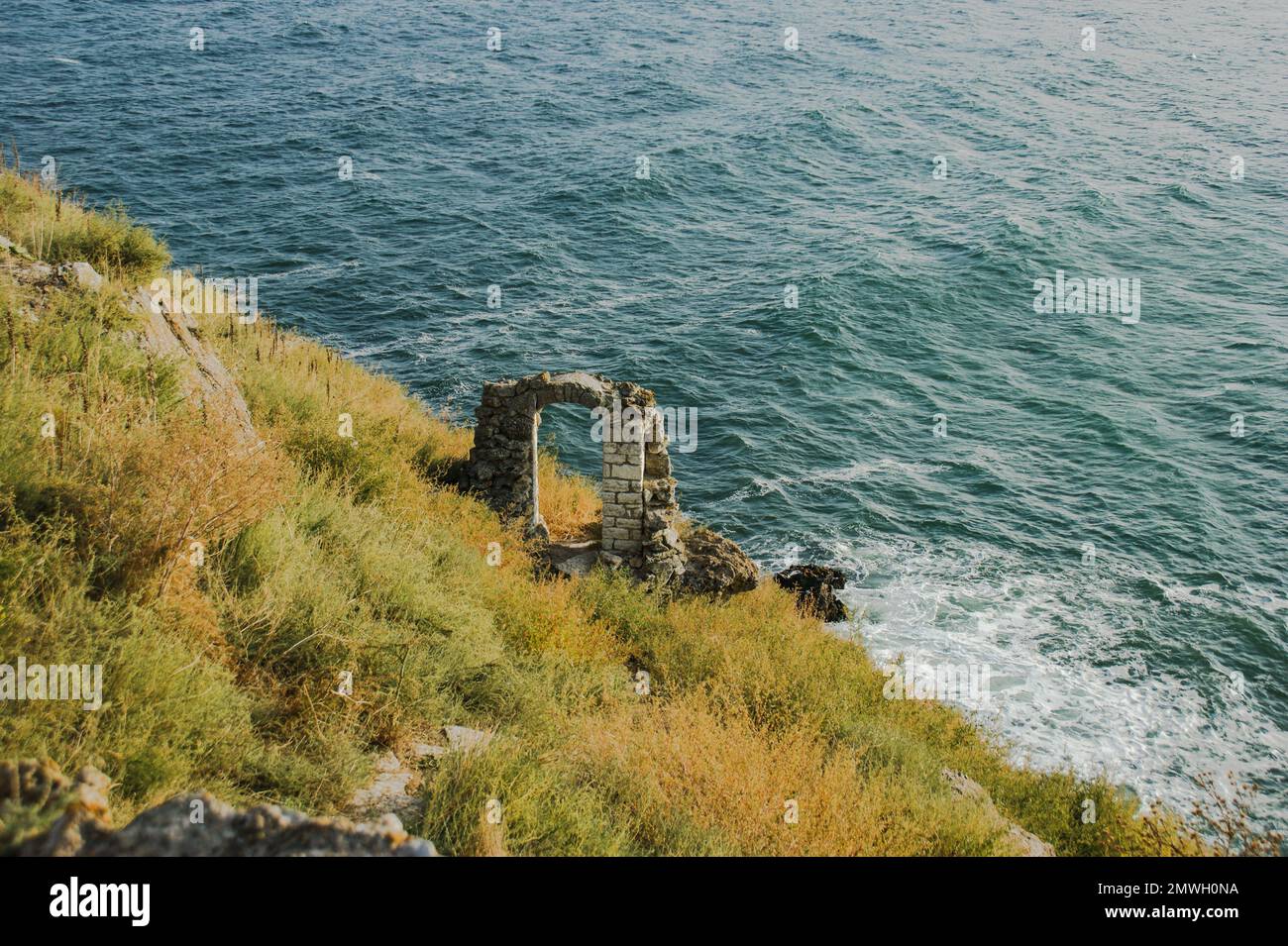 A stone arch on the edge of the mountain over the ocean Stock Photo - Alamy