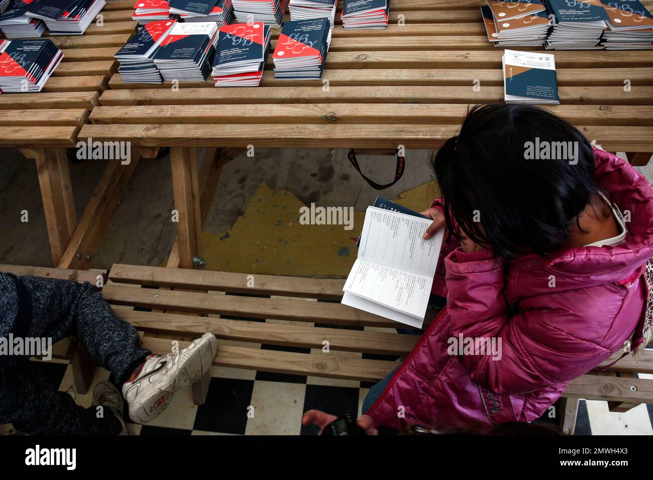 A girl browses through the pages of a lexicon at Eleonas refugee camp ...