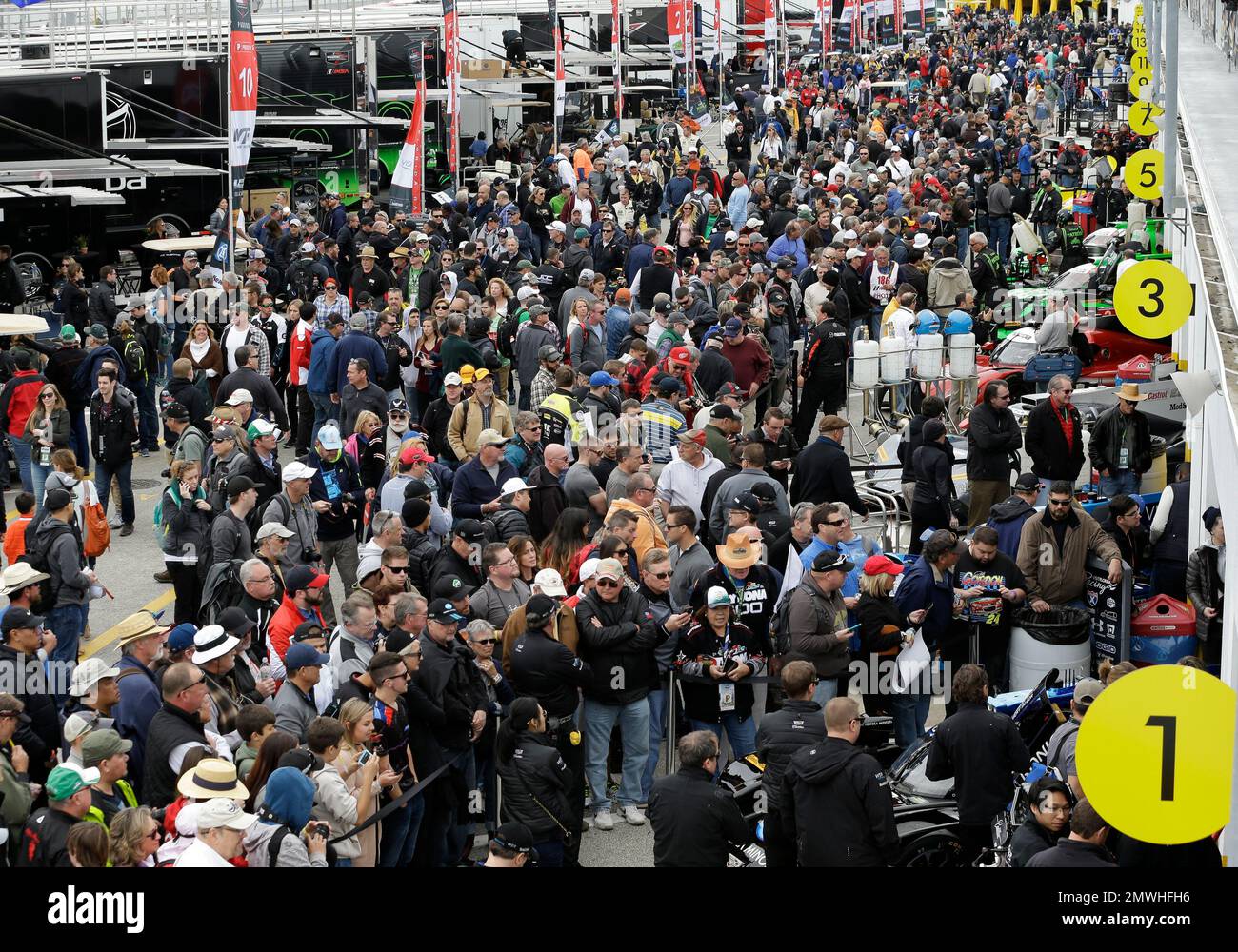 Race fans crowd the garage area for a look at the race cars before they ...