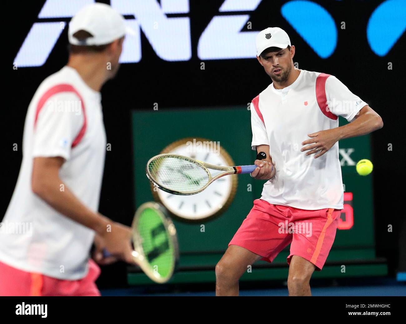 Mike Bryan of the U.S. plays a forehand return as brother Bob watches ...