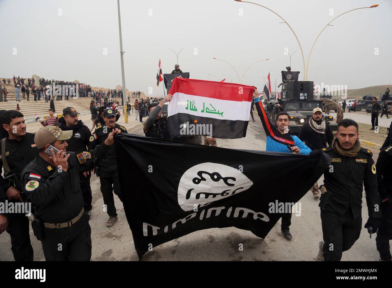 Iraqi special forces troops hold a flag of the Islamic State group as ...