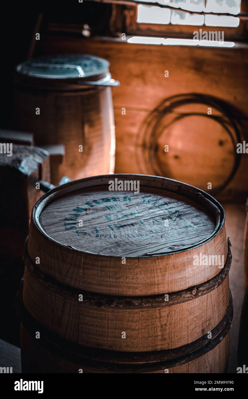 A vertical shot of an old wooden barrel at a local factory in a small ...