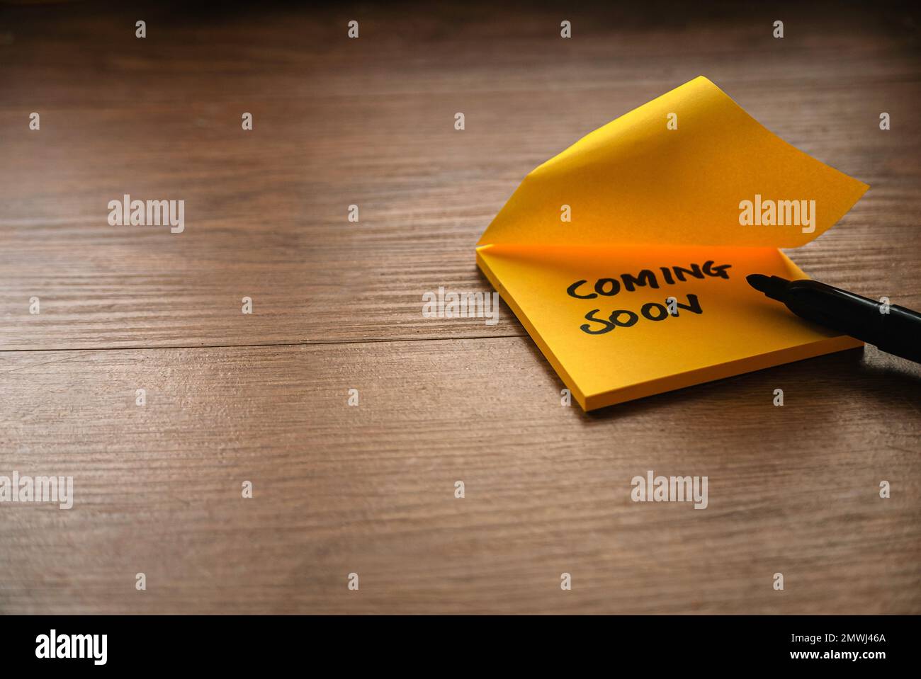 Coming soon written on a yellow paper with a black marker pen Stock ...