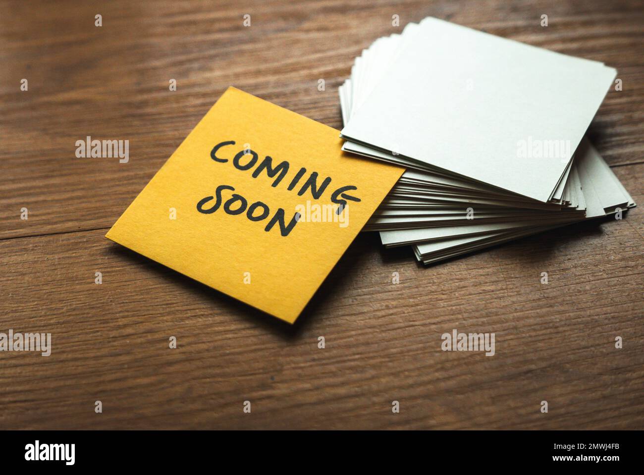 A yellow card among an empty white card written with coming soon Stock ...