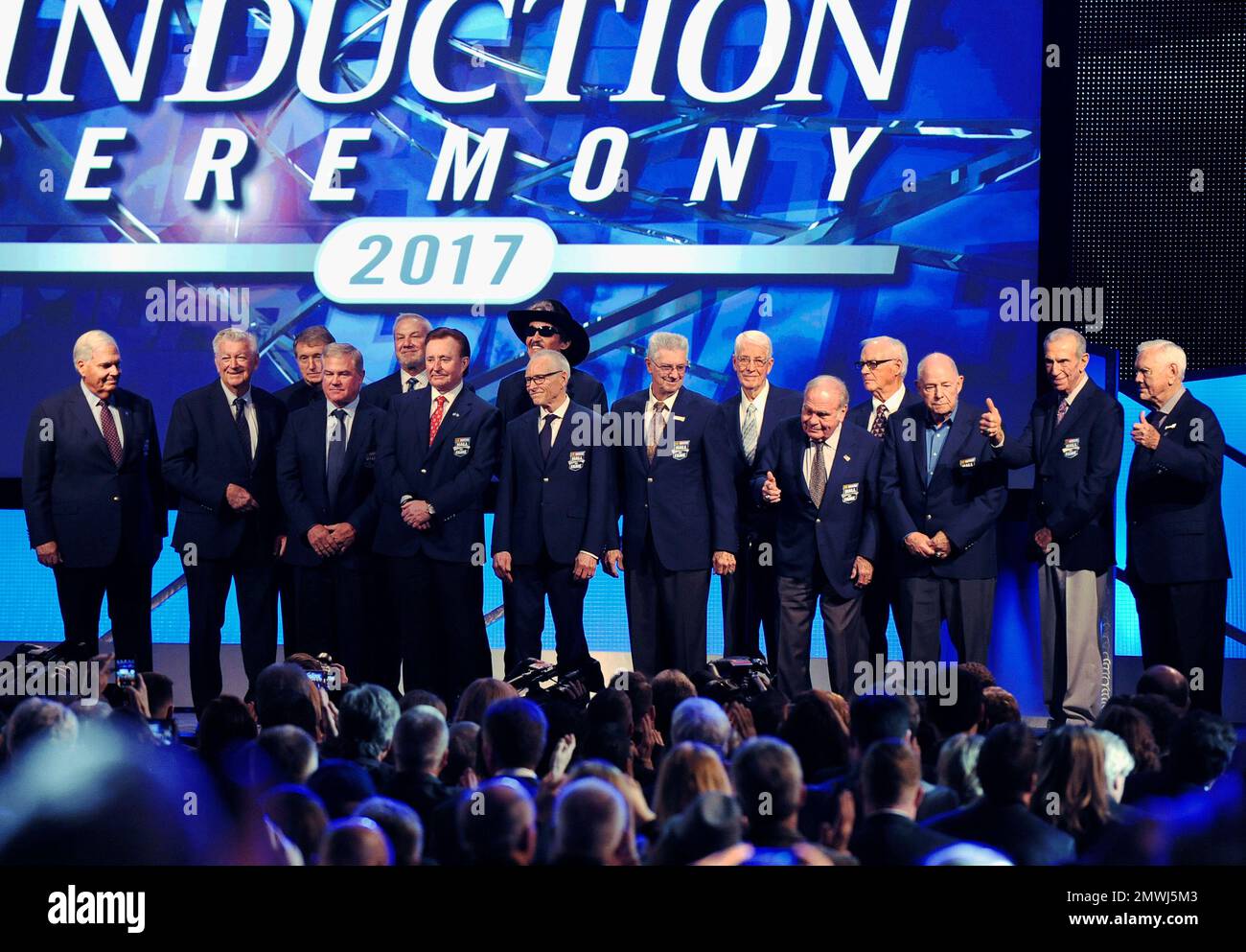 Hall of Fame members in attendance gather as a group on the stage after ...