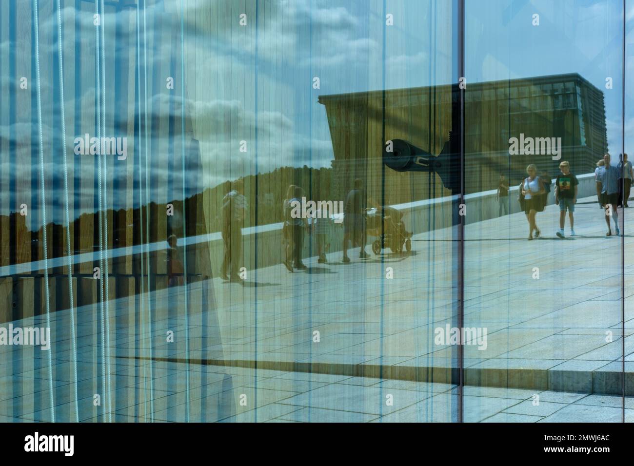 A group of people walking on the street reflected in the glass window ...