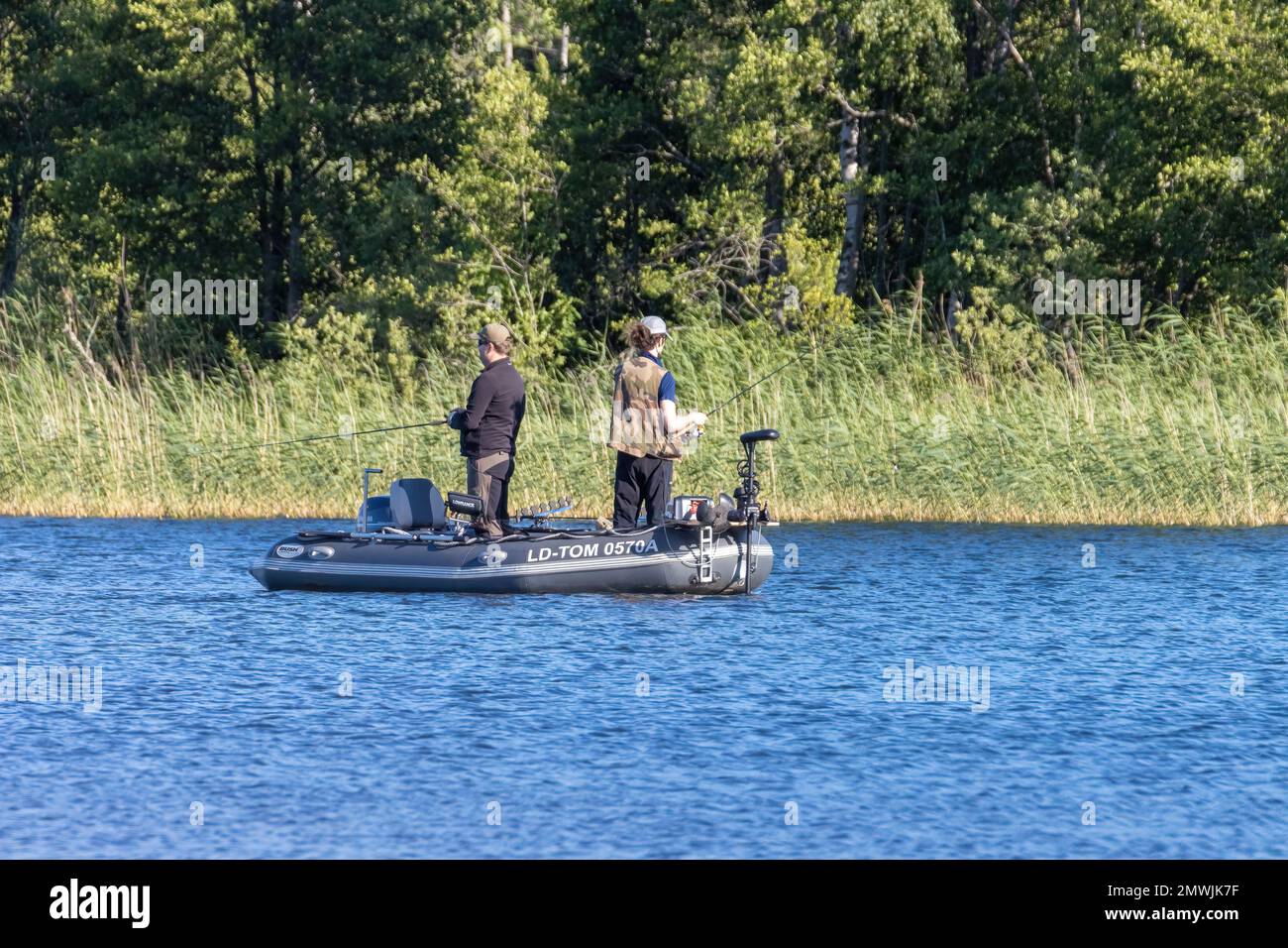 A fishing boat on river surrounded by trees Stock Photo - Alamy