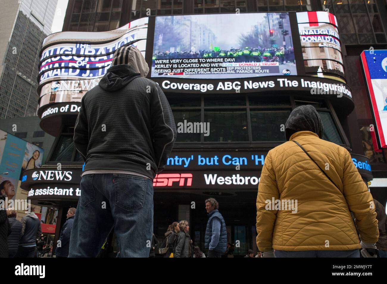 Visitors to New York's Times Square watch the a jumbotron displaying ...