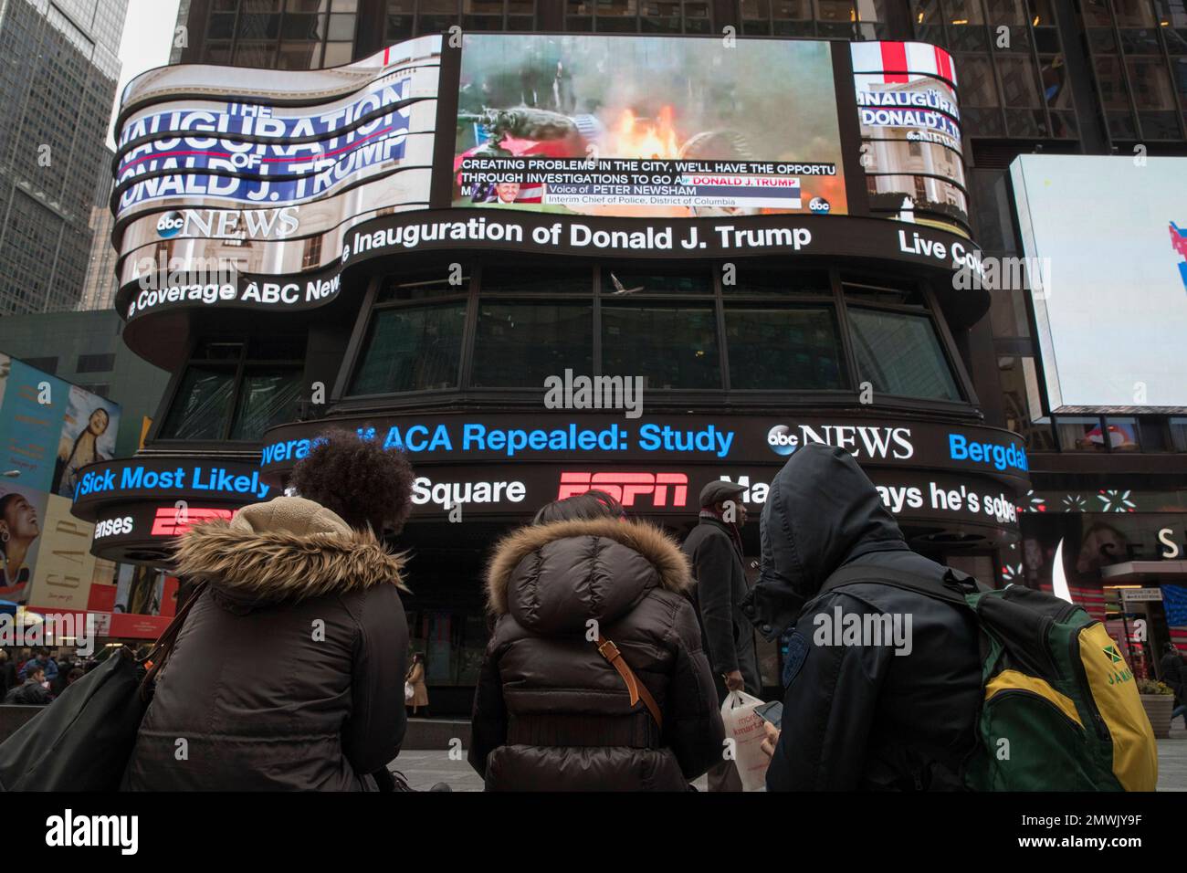 Visitors to New York's Times Square watch the a jumbotron displaying ...