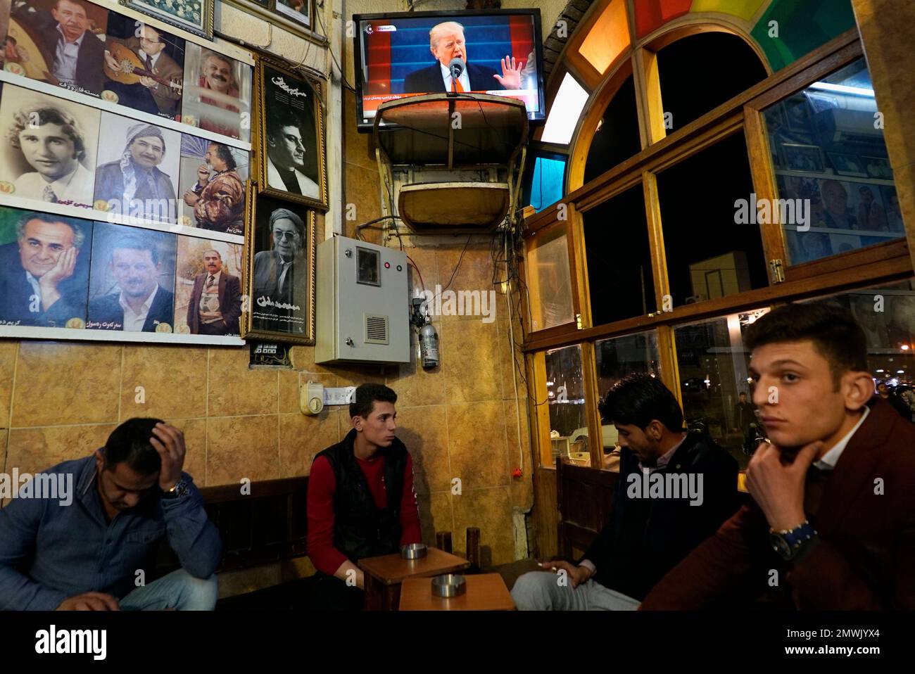 Iraqi Kurdish people sit in a popular cafe as a live TV broadcasts the ...