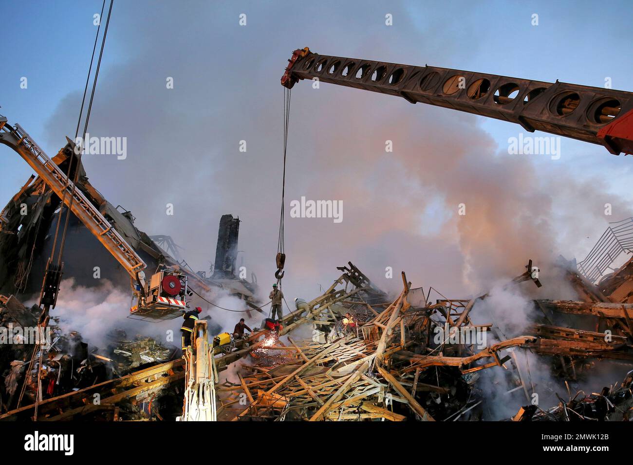 Iranian firefighters remove debris of the Plasco building which was ...