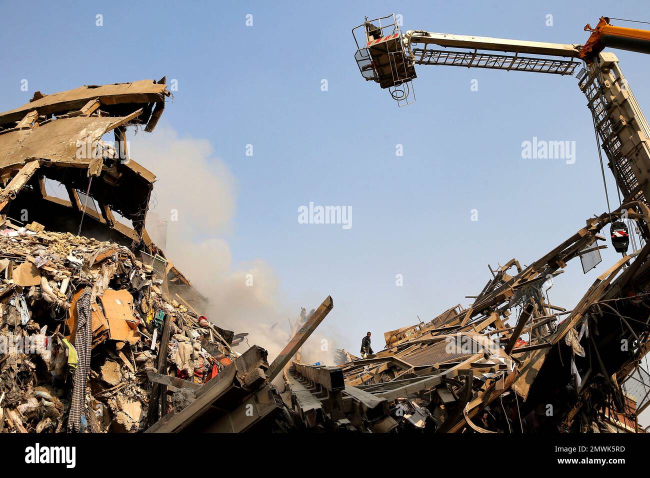Iranian firefighters work at the scene of the collapsed Plasco building ...