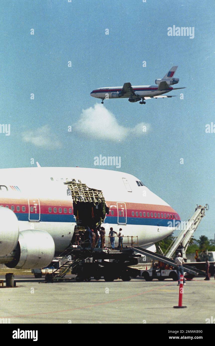 A United Airlines jet flies over the damaged 747 jumbo jet which made ...