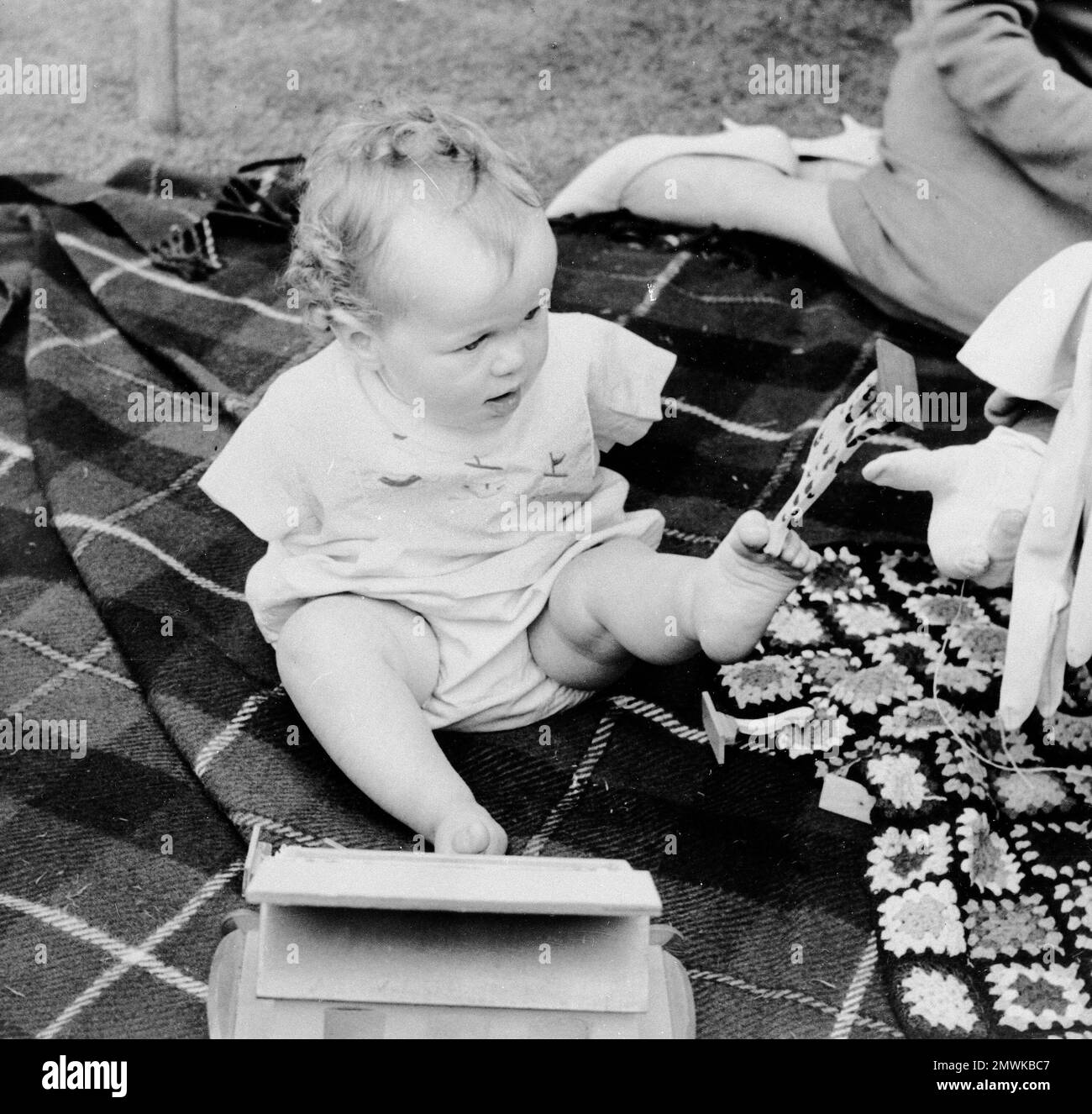 Thomas Yendell, 16 months old, picks up toys with his feet during a ...