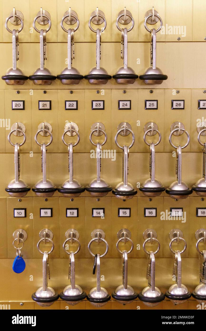 Three rows of old-fashioned metal hotel keys with a lone blue key Stock ...