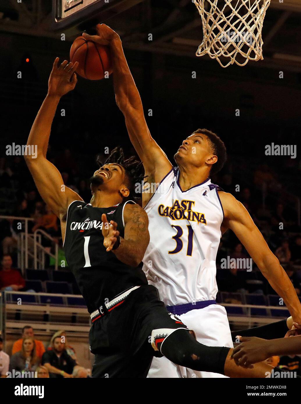 Cincinnati's Jacob Evans (1) has his shot blocked by East Carolina's ...