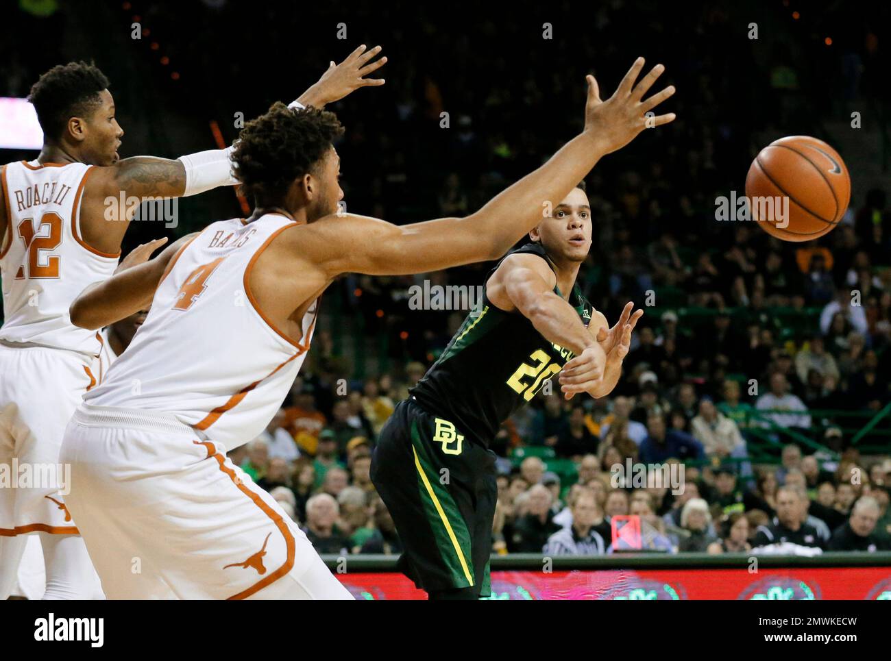 Texas's Kerwin Roach Jr. (12) and James Banks (4) defend as Baylor's Manu Lecomte (20) passes ...