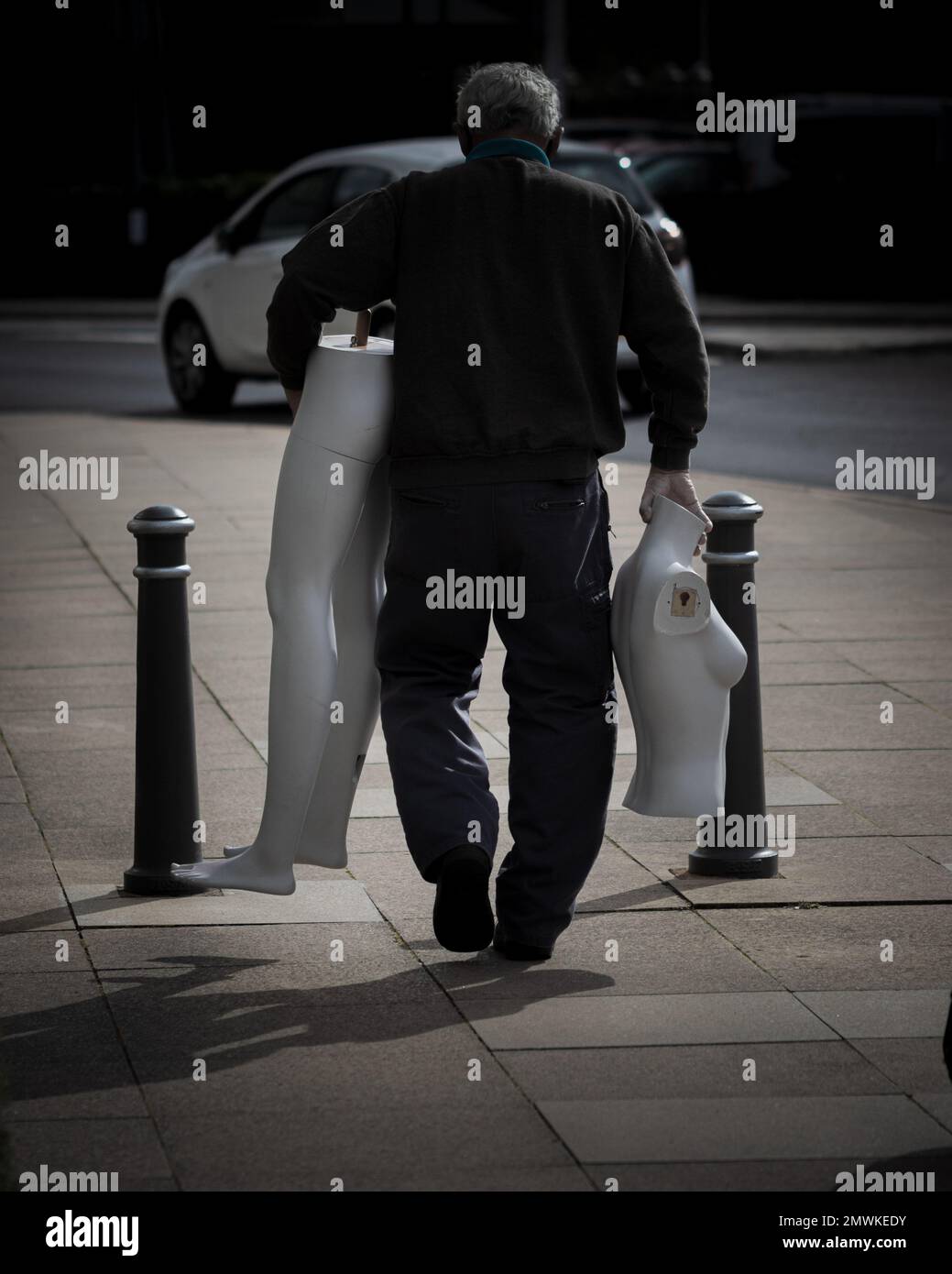 A vertical shot of an adult man carrying parts of a mannequin Stock ...