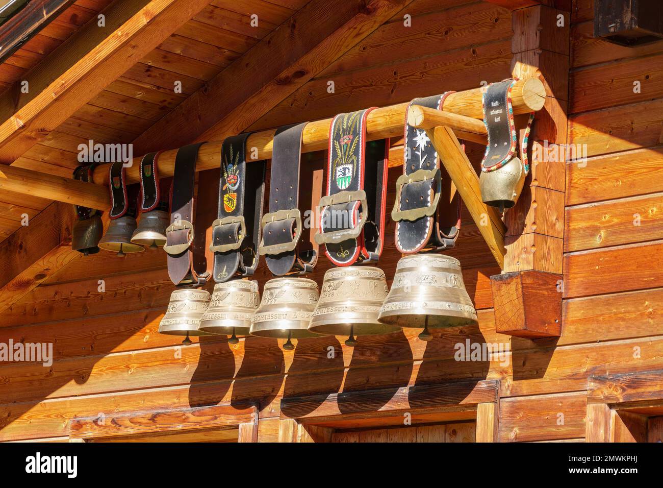 A row of oversized traditional cowbell decorations adorn a wooden house ...