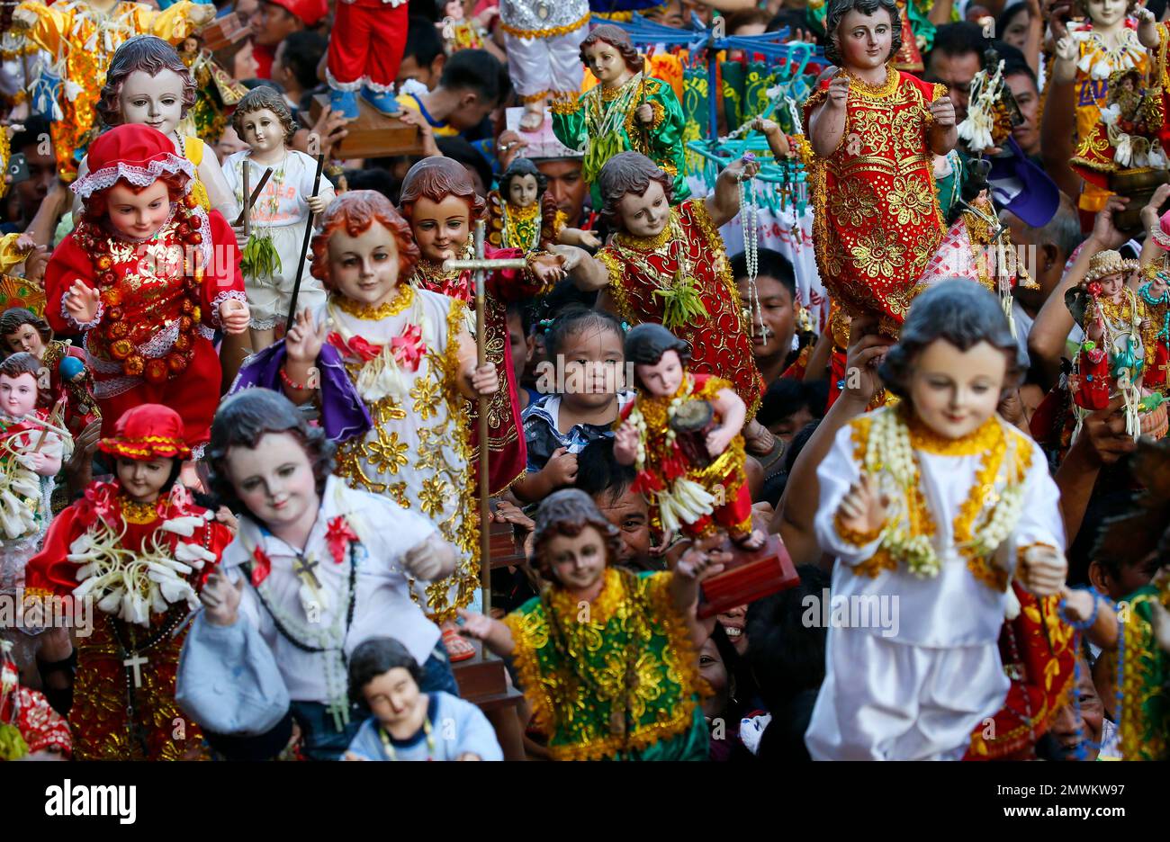 Roman Catholic devotees raise their images of the Child Jesus to be ...