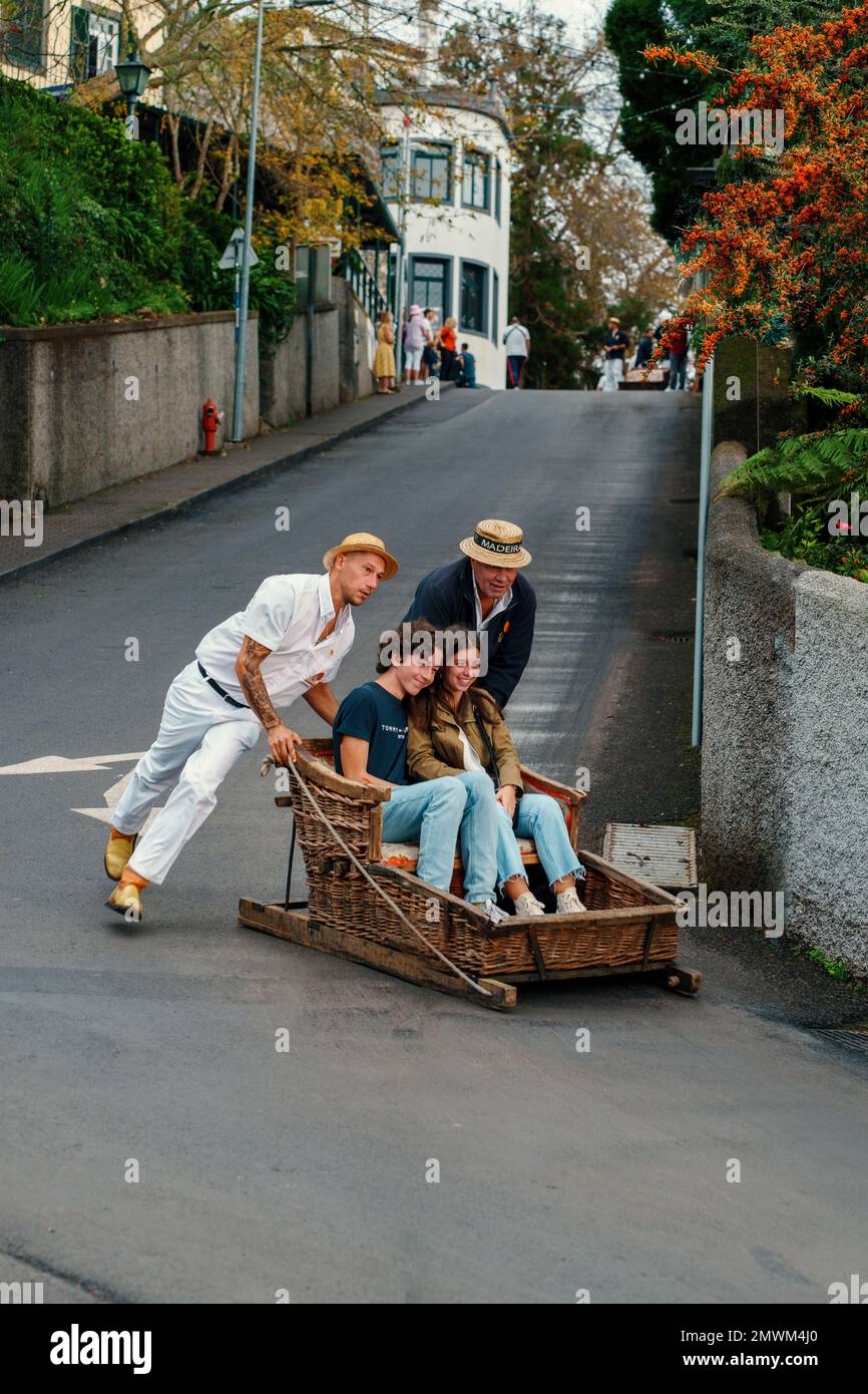 A group of people during traditional sleigh ride in Madeira, Portugal ...