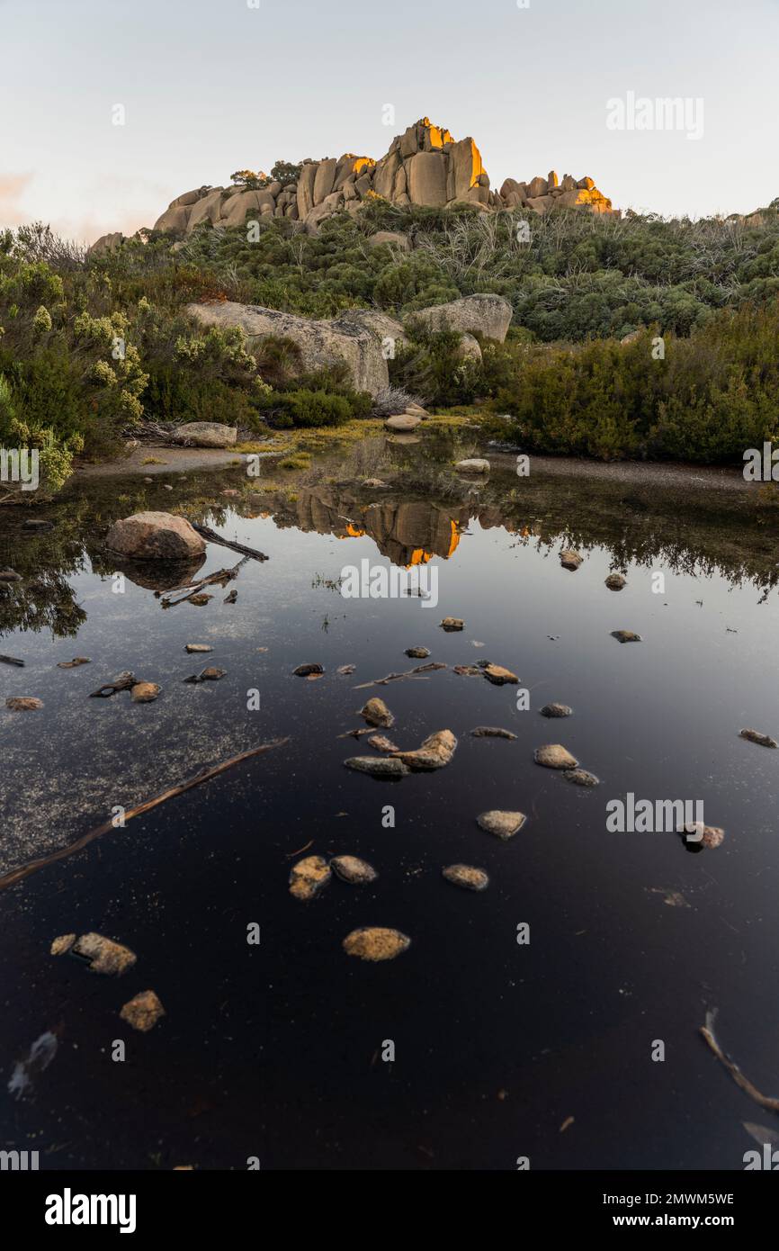 A vertical shot of rocks in shallow stream and rocky hills in Mount ...