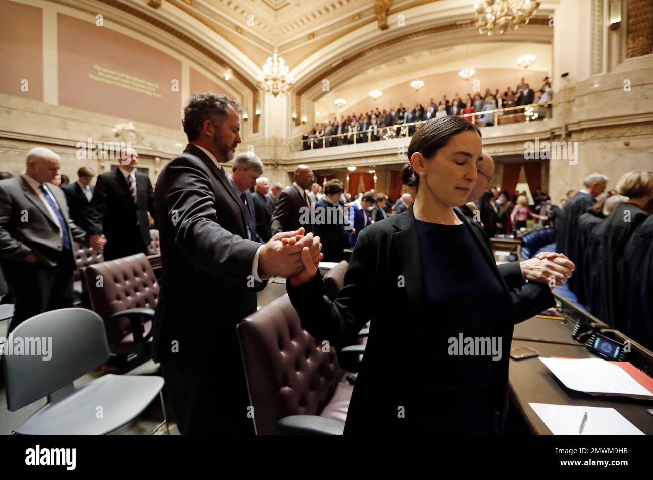 Sen. Rebecca Saldana, D-Seattle, center, holds hands with fellow ...
