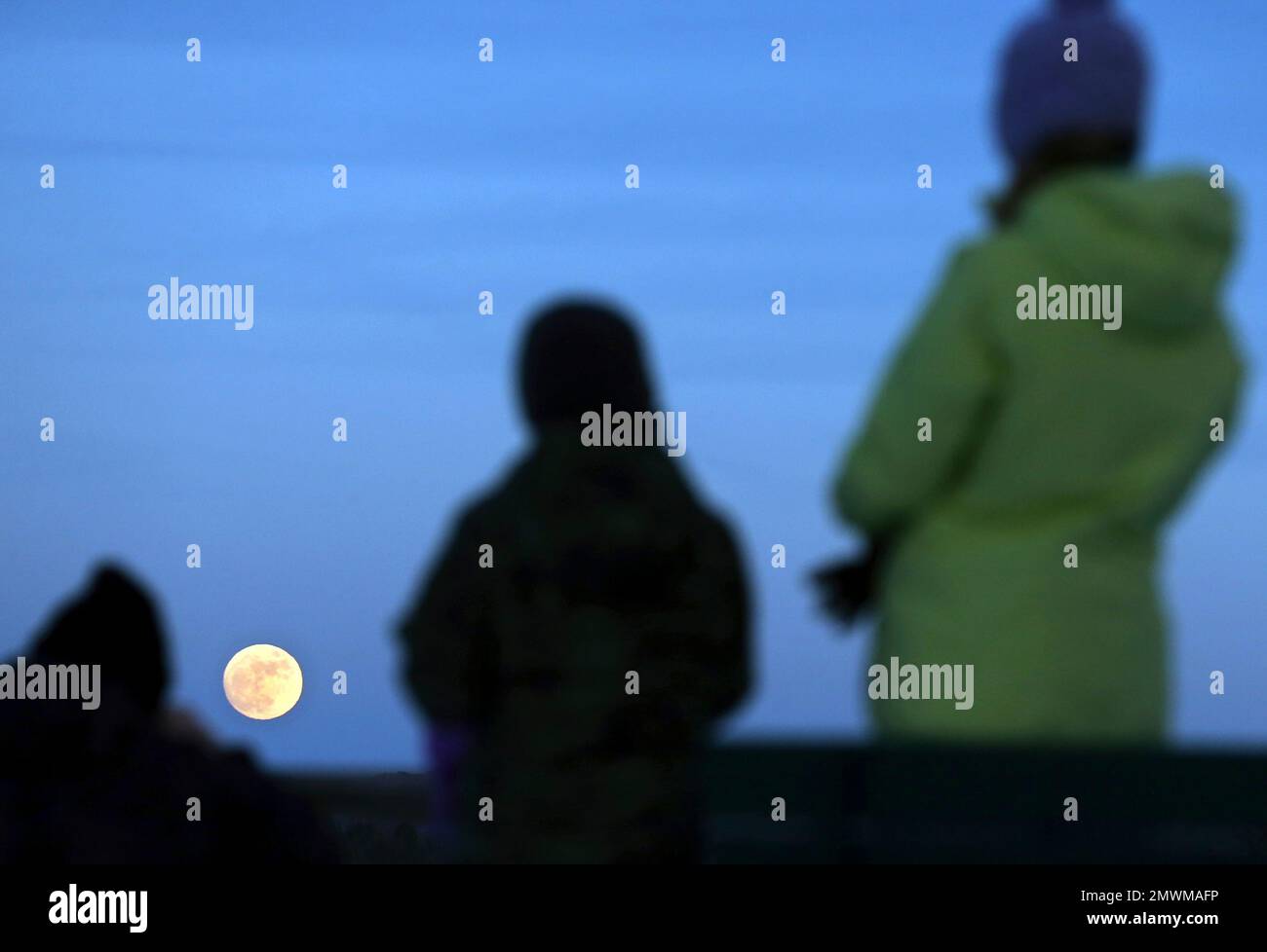 People stop to watch the moon rising over Mirror Lake, Wednesday, Jan ...
