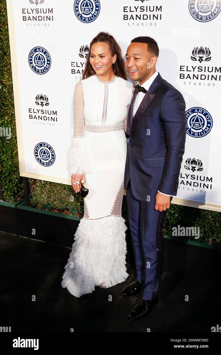 Chrissy Teigen, left, and John Legend arrive at The Art of Elysium's ...