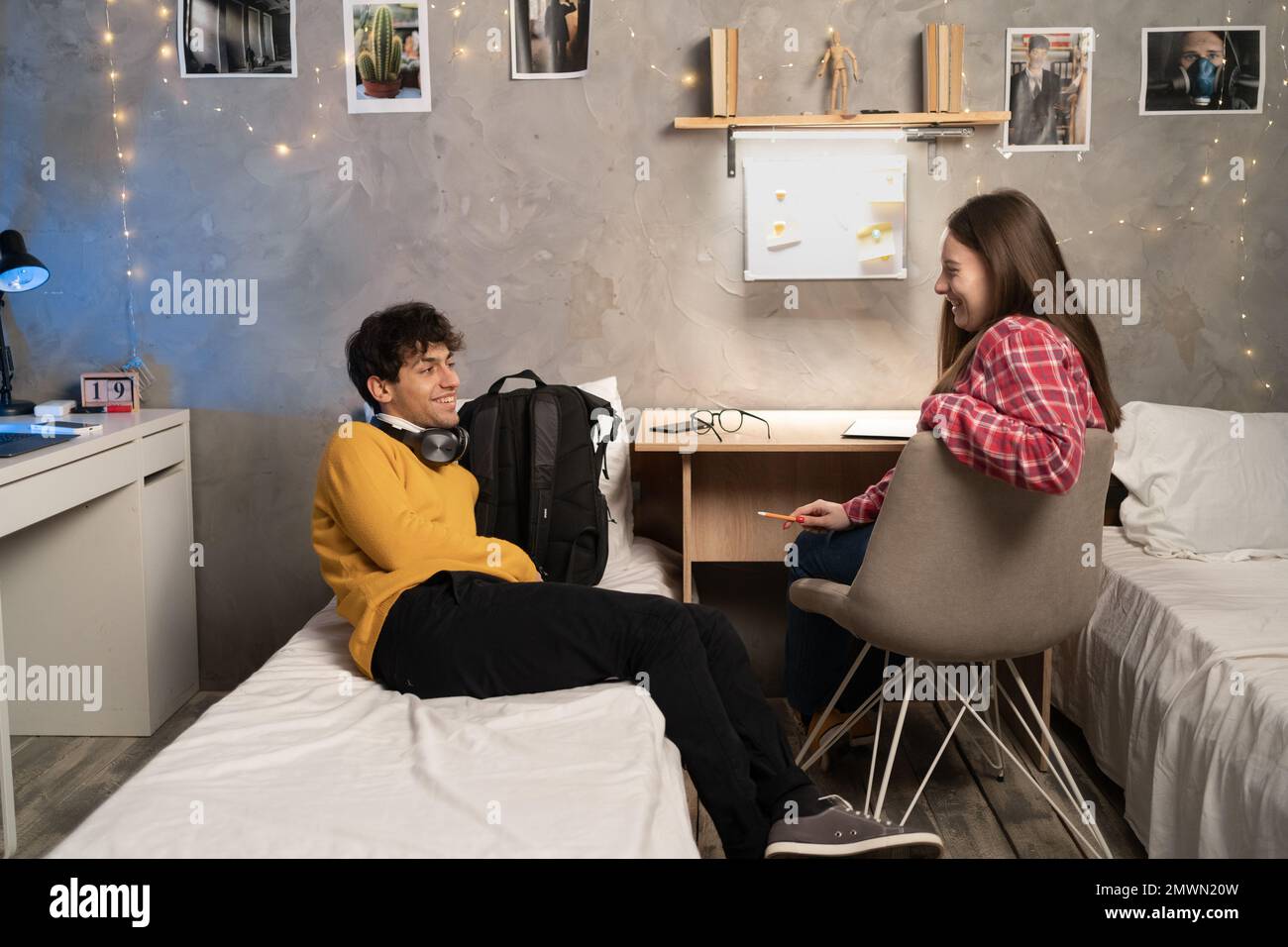 Man and woman students communicate in a dorm room. Friends spend time ...
