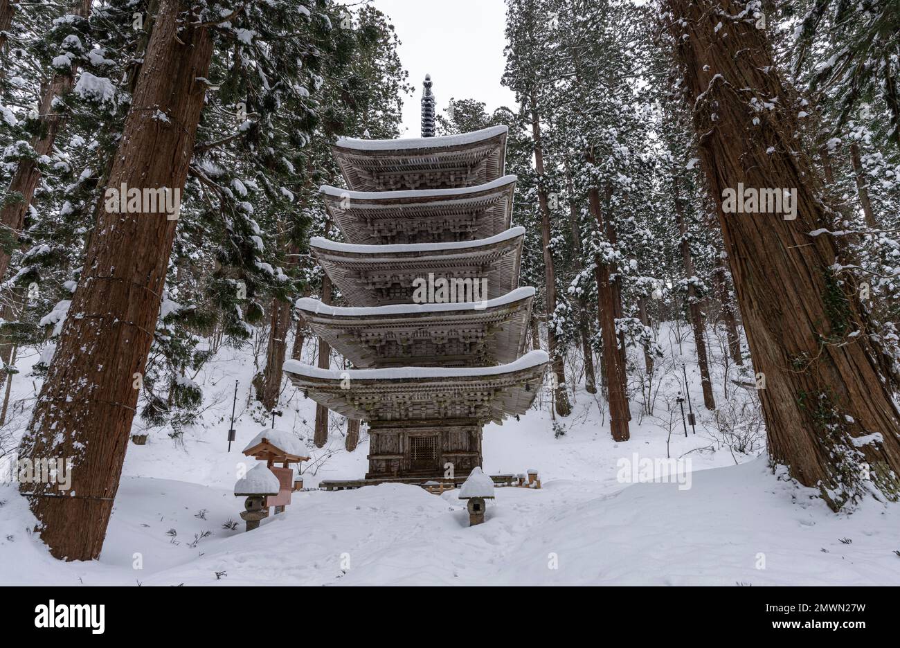 The five-storied pagoda in a forest of cedar trees with deep snow at ...