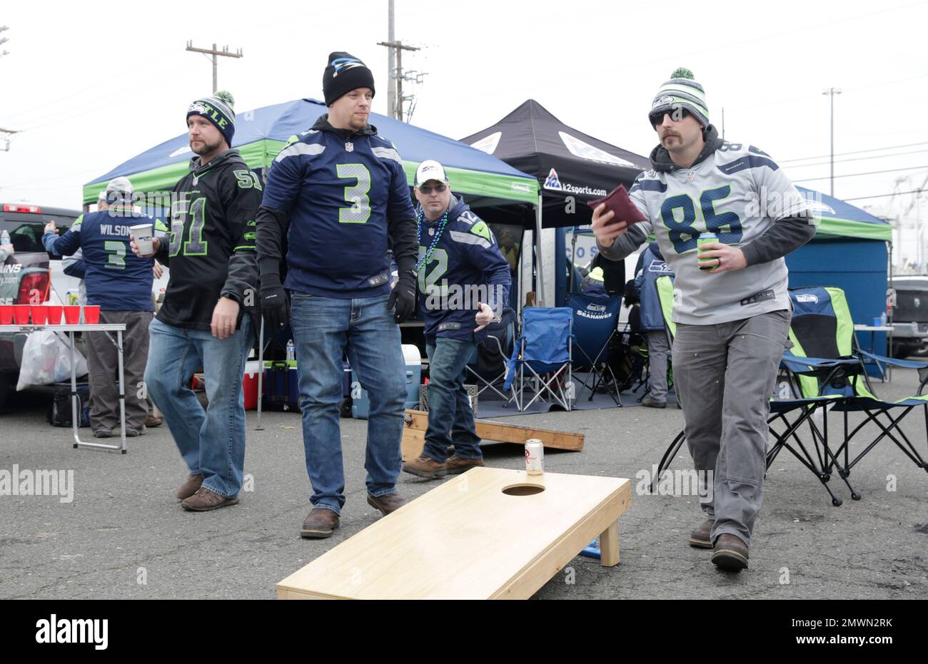 Seattle Seahawks fan Mike Braaten, right, tosses a beanbag as he plays ...