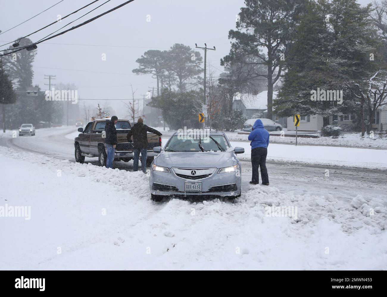 Good samaritans help pull a woman's car out of the snow during ...