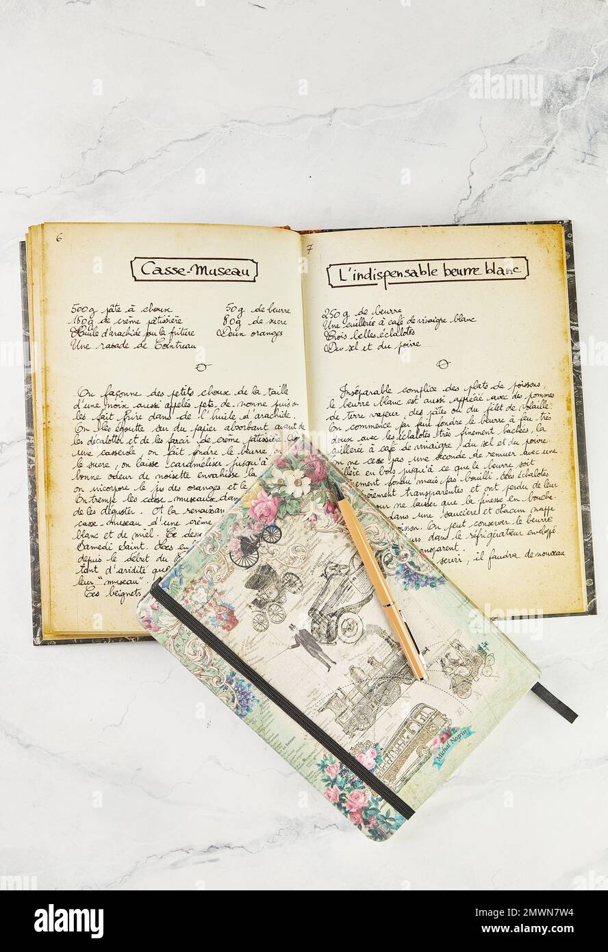 Old book with recipes in French and notebook for writing with pen on ...