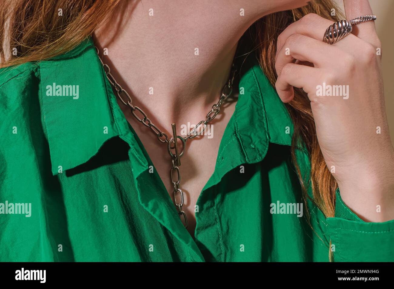 Unrecognizable woman in a green shirt wearing gold chain necklace ...
