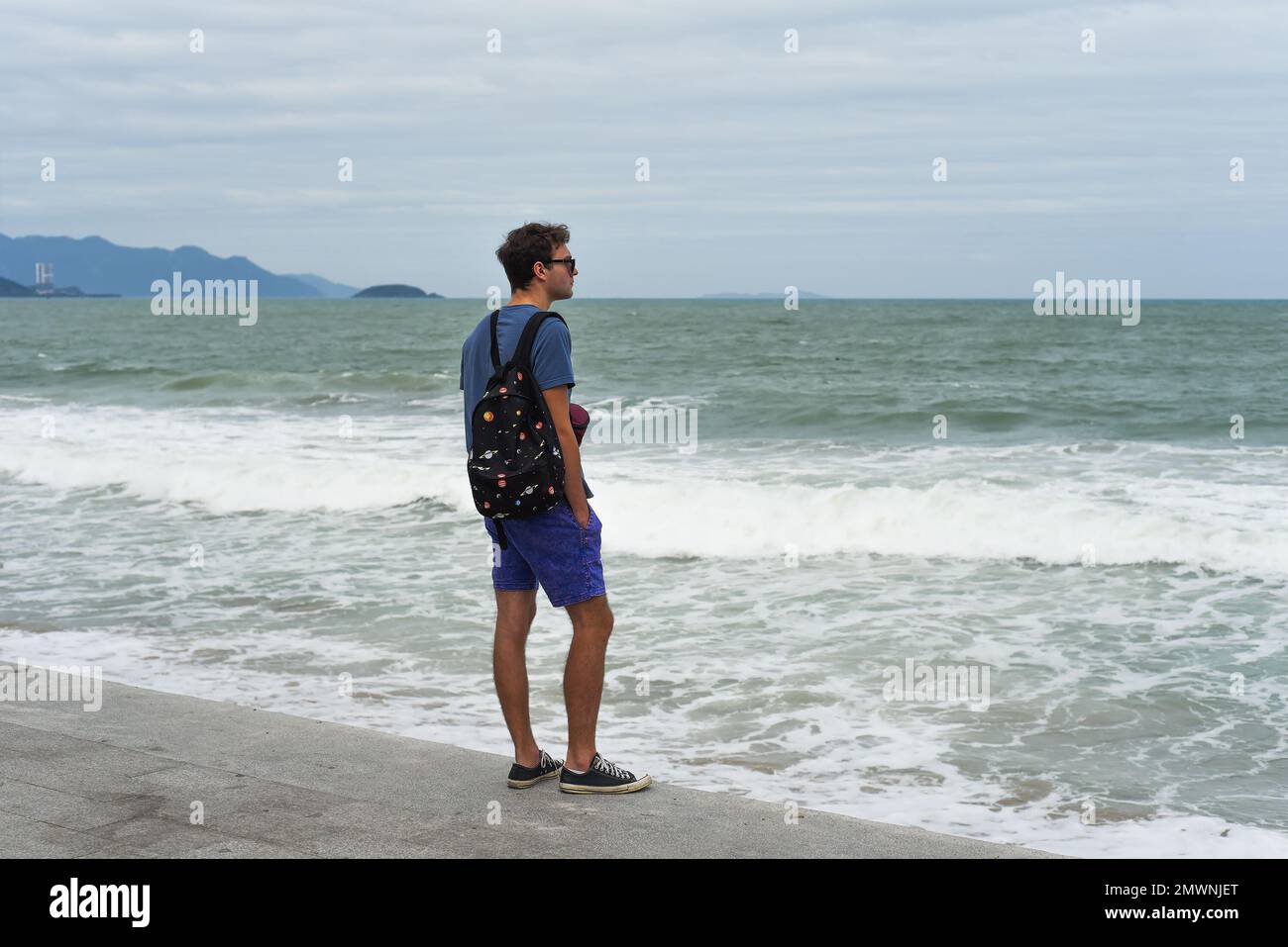Sad man looks at a stormy sea in bad weather as a depressive concept ...