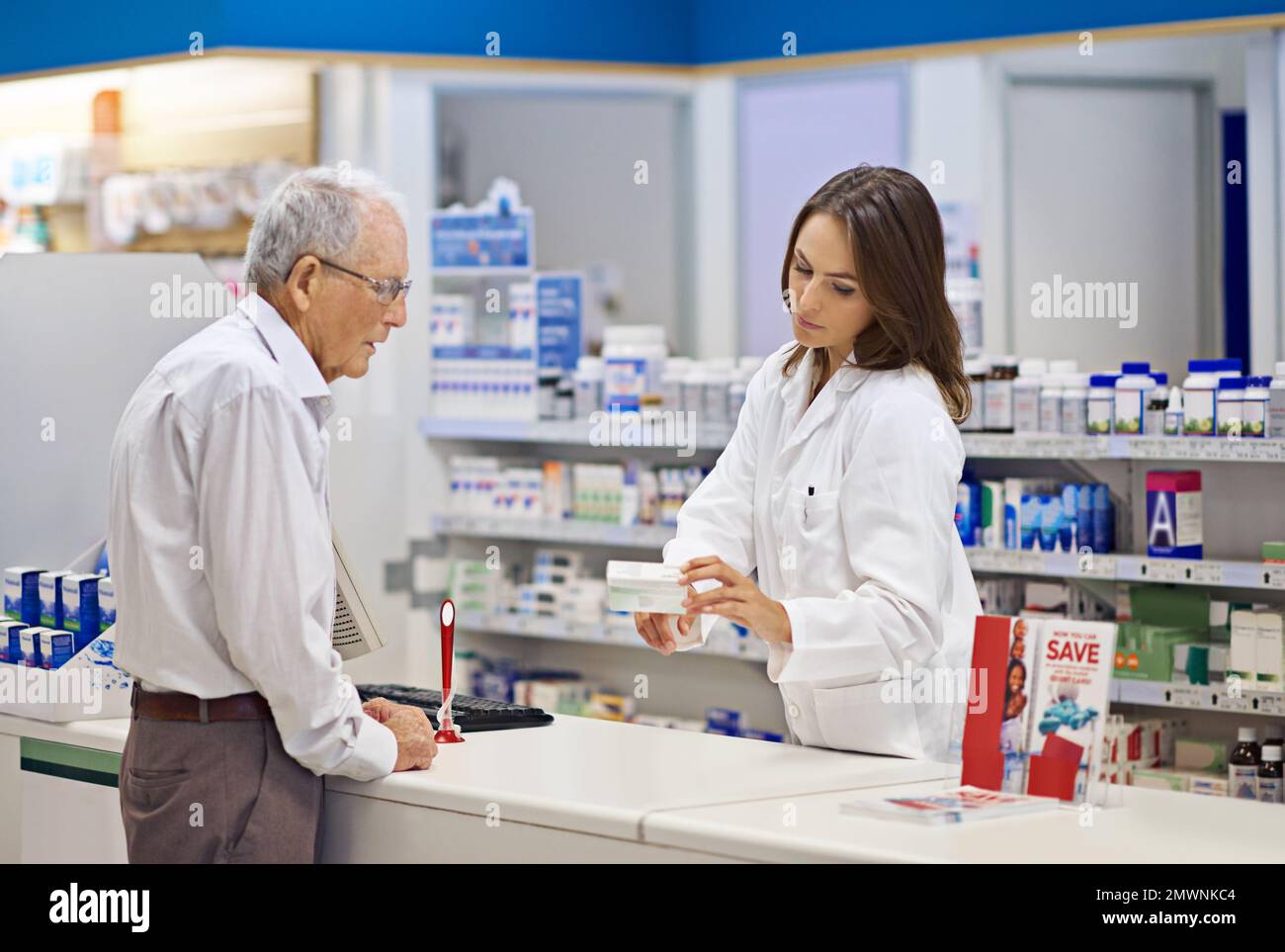 Providing customers with the medication they need. a young pharmacist ...