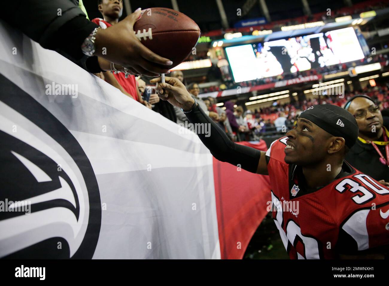 Atlanta Falcons cornerback Deji Olatoye (30) hands a football to a fan after an NFL football ...