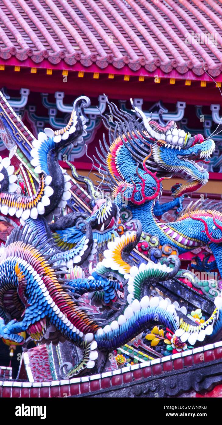 A vertical shot of a dragon sculptures on a temple roof Stock Photo - Alamy
