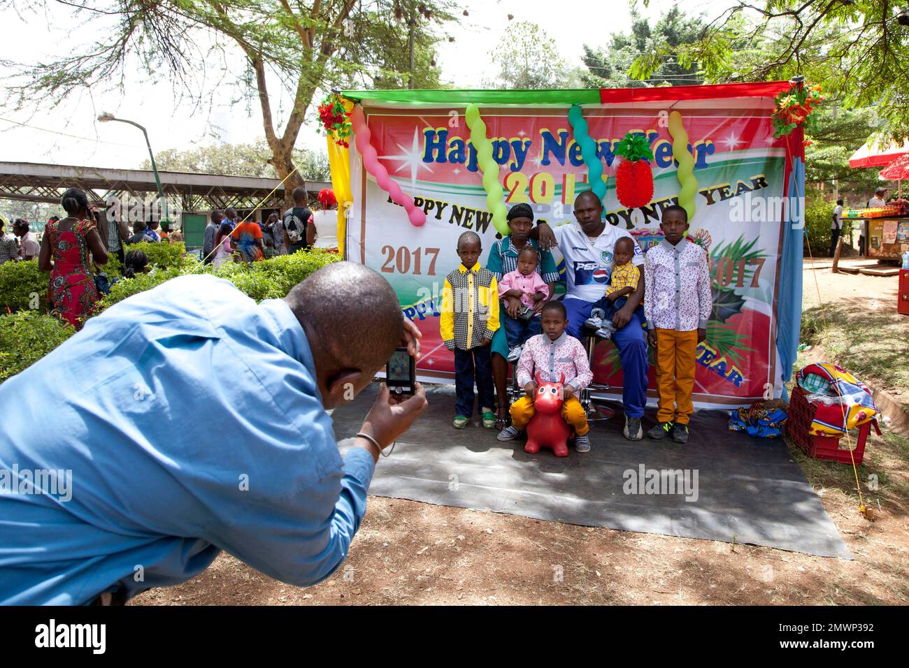 A Kenyan man takes a family photo as families gather at Uhuru Park ...